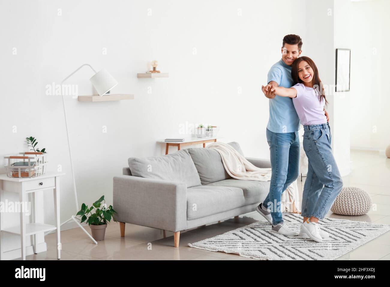 Happy young couple dancing at home Stock Photo - Alamy