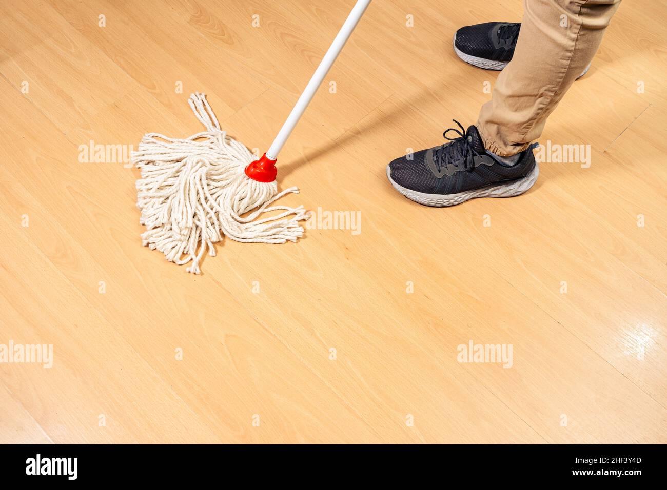 Home cleaner, man cleaning driftwood floors with rope mop. Housework ...