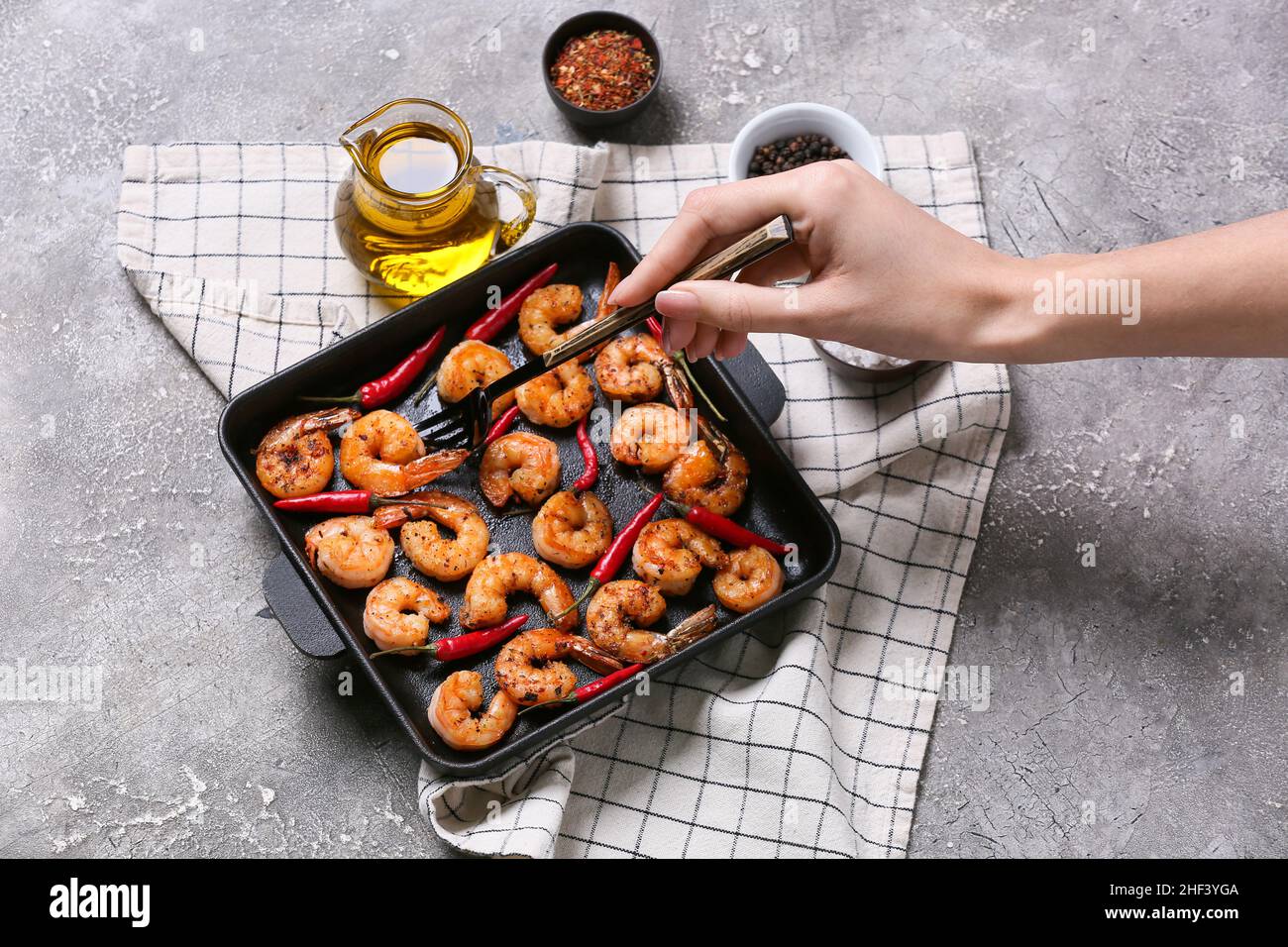 Woman eating tasty shrimp tails on grey background Stock Photo - Alamy