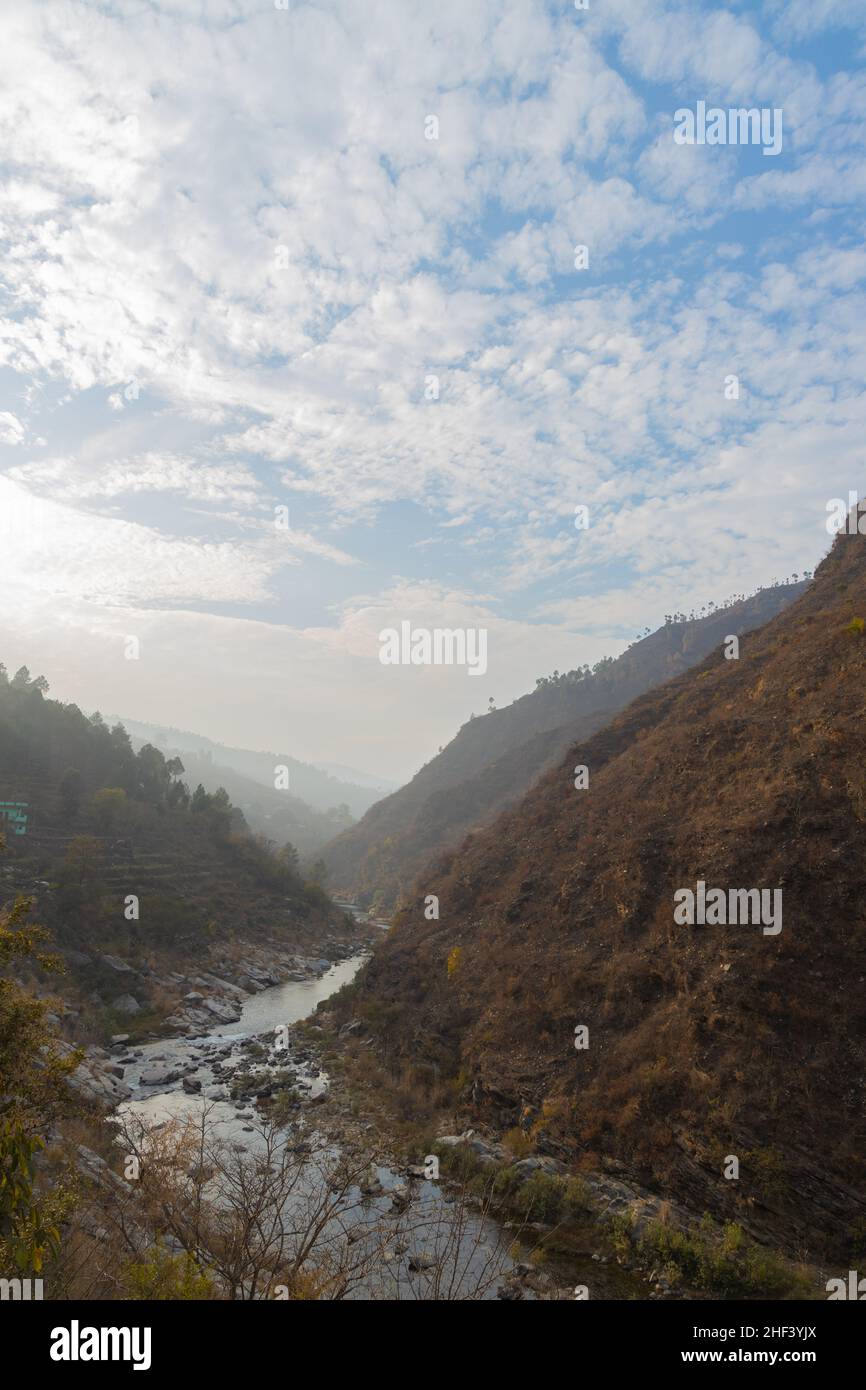 A view of a river flowing through a narrow valley with stones and rocks ...