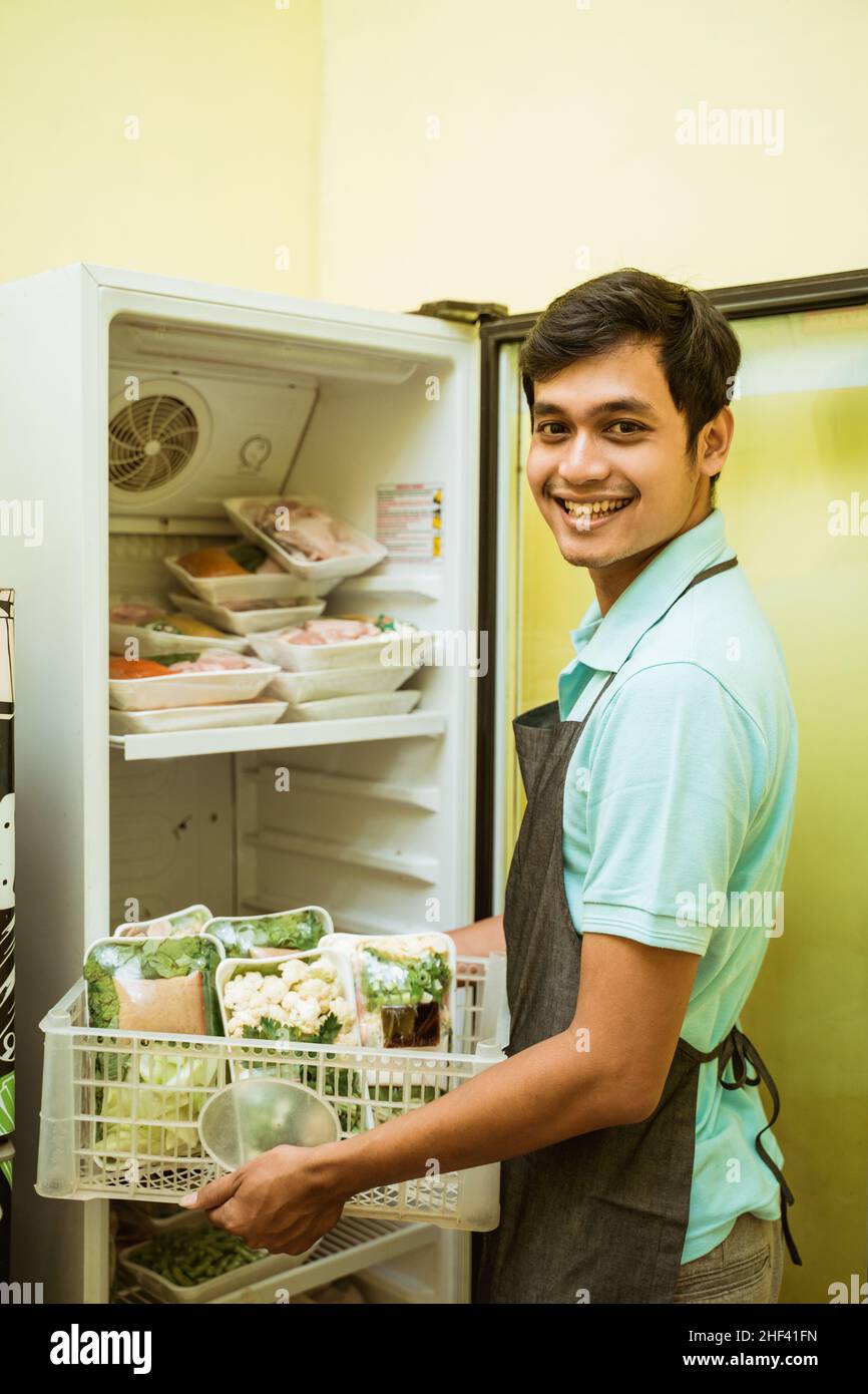 Man carrying a packaged vegetables to put in the fridge Stock Photo - Alamy