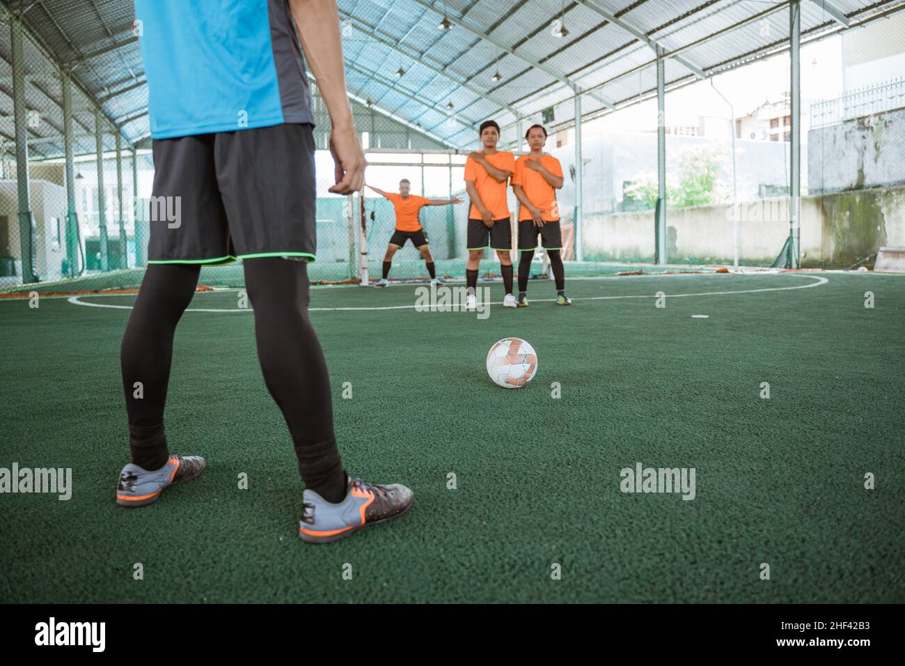 Players preparing to kick the ball blocked by a posse Stock Photo - Alamy