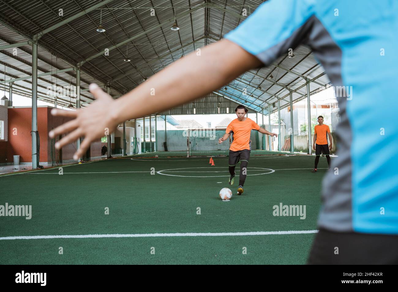 player kicks the ball towards the goalkeeper while playing futsal Stock ...
