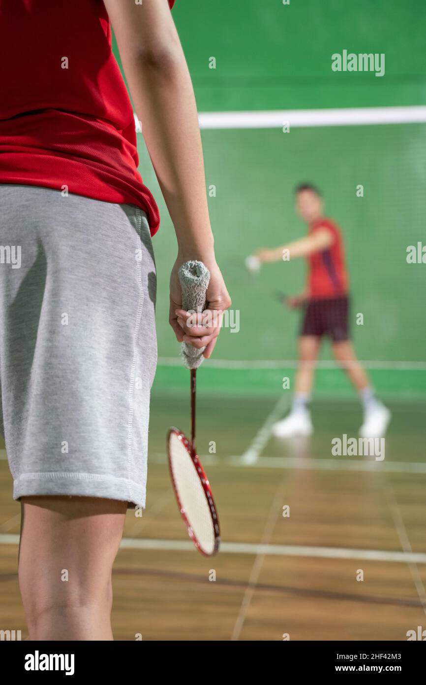 A badminton player's hand holding a racket while playing badminton ...