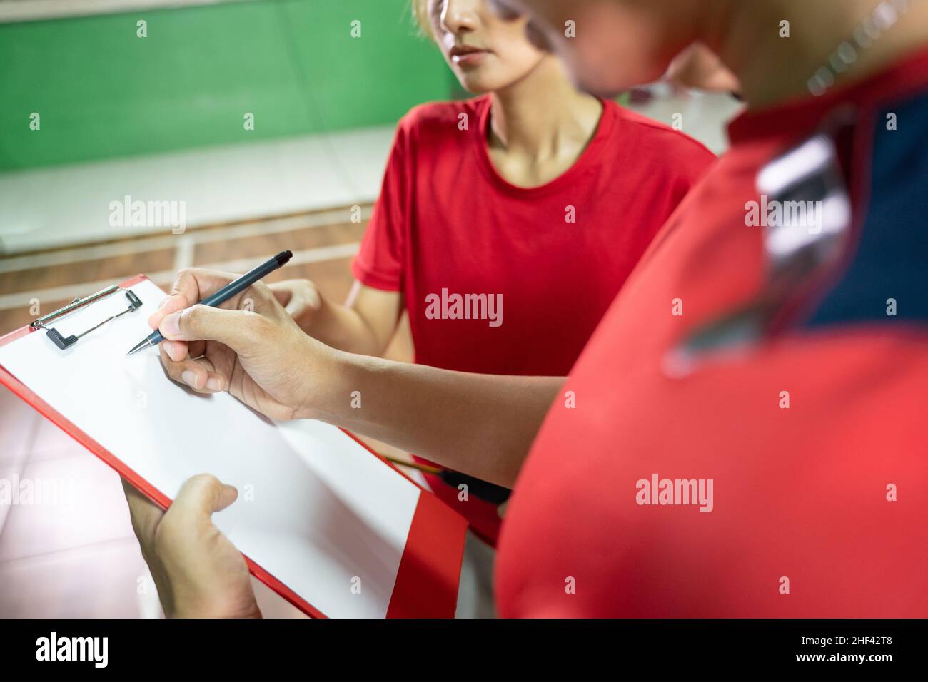 Coach gives instructions to players using pen and clipboard Stock Photo ...