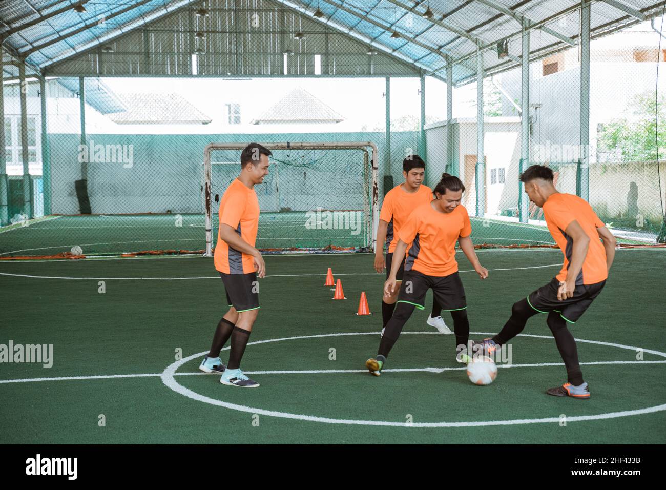 four futsal players practice with the ball Stock Photo - Alamy