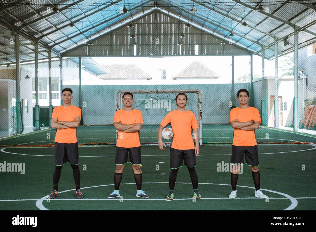 four futsal players standing in a row carrying the ball Stock Photo - Alamy