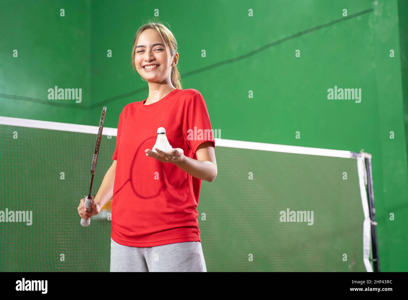 Smiling female badminton player holding racket and shuttlecock Stock ...