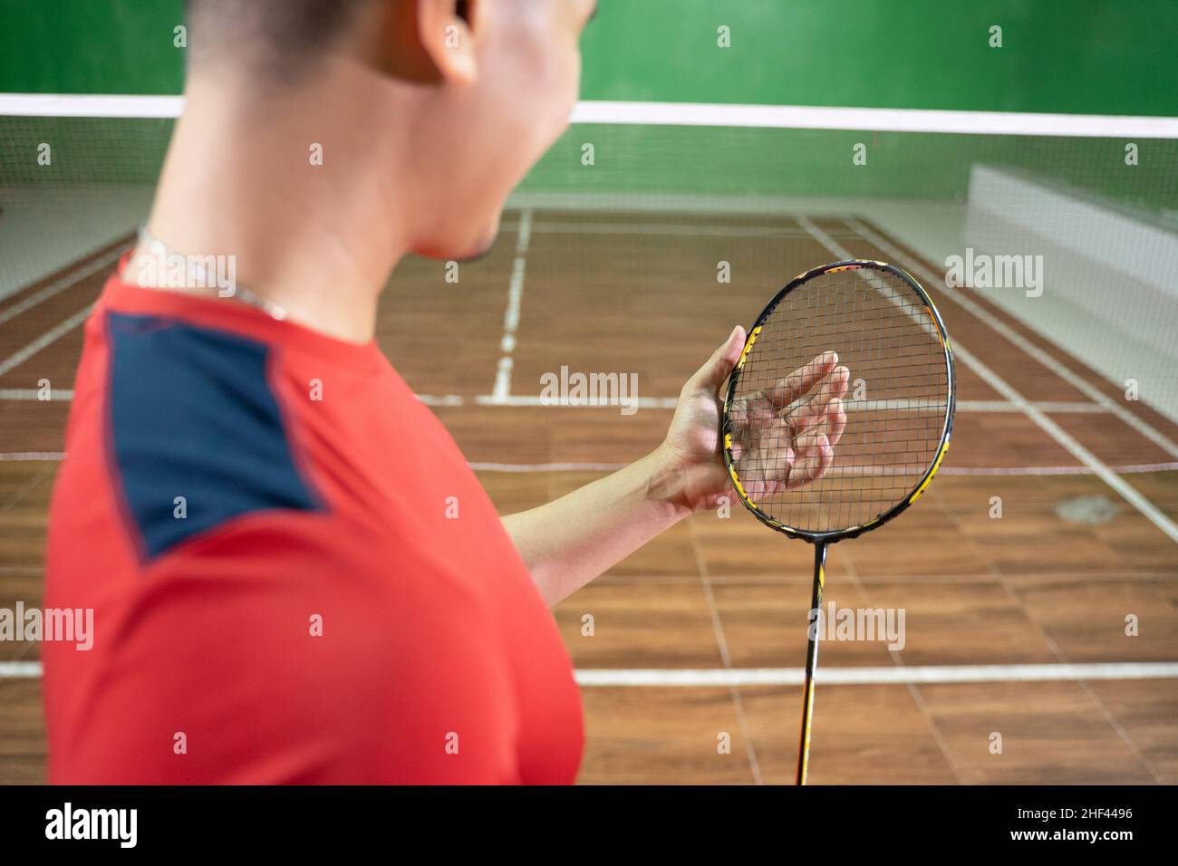 Male badminton player's hand holding racket strings to check Stock ...