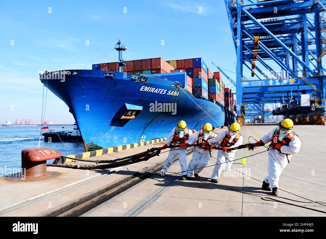 QINGDAO, CHINA - JANUARY 14, 2022 - Dockworkers wait to attach cables ...
