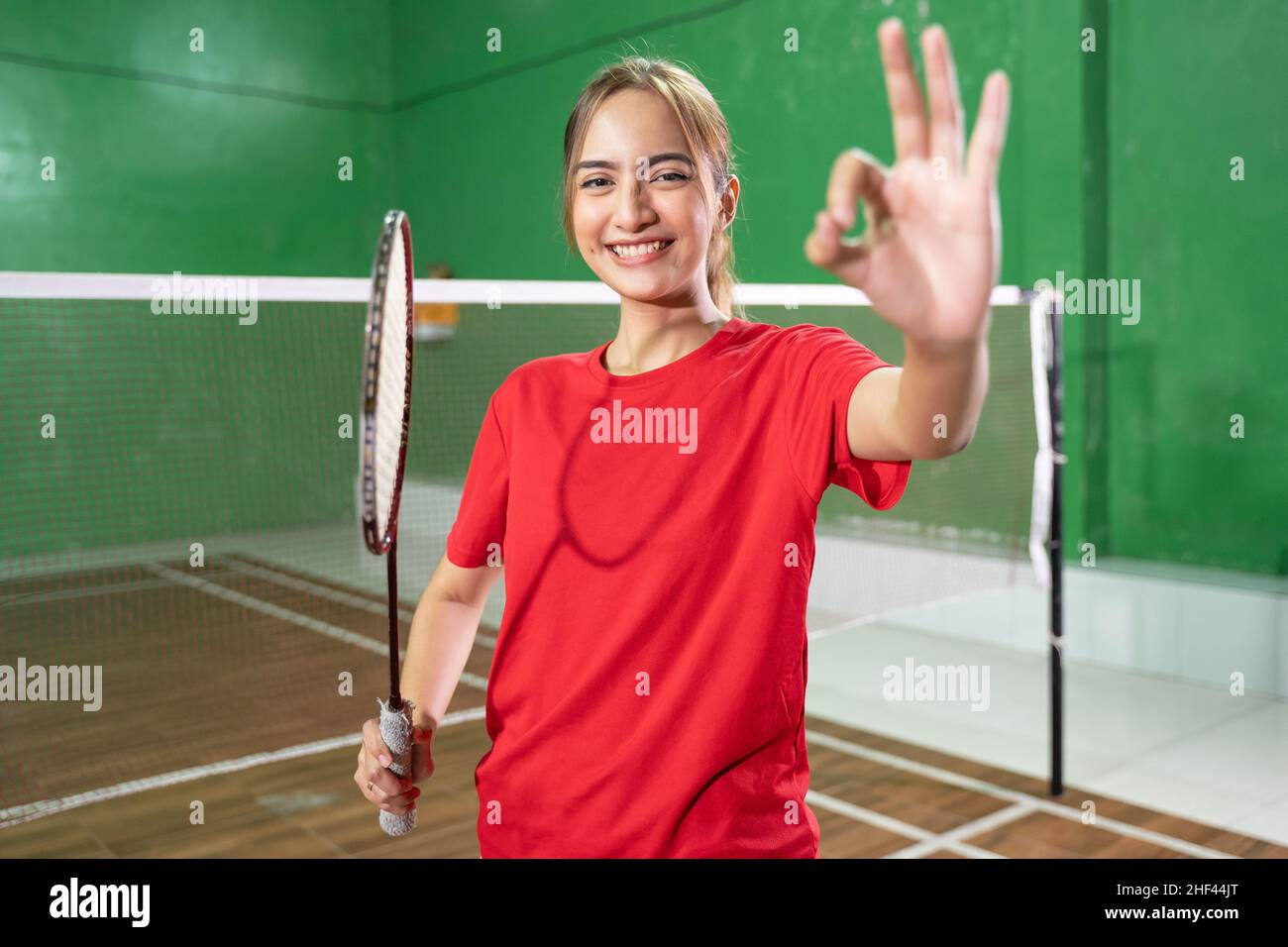 Beautiful girl badminton player with okay gesture holding racket Stock ...