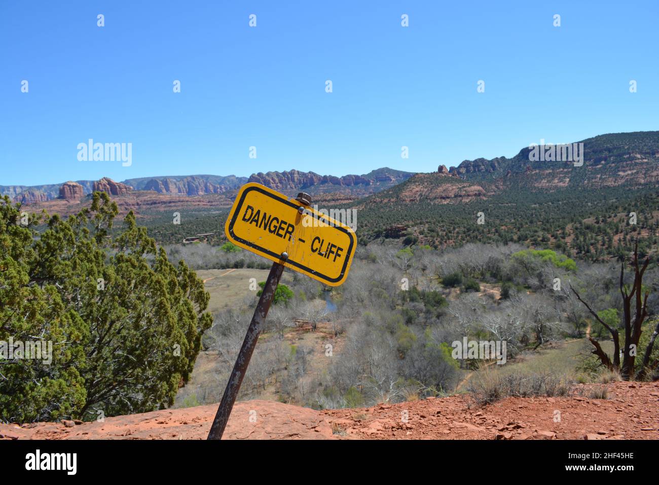 A yellow warning sign on a hiking trail in Sedona, Arizona, in the ...