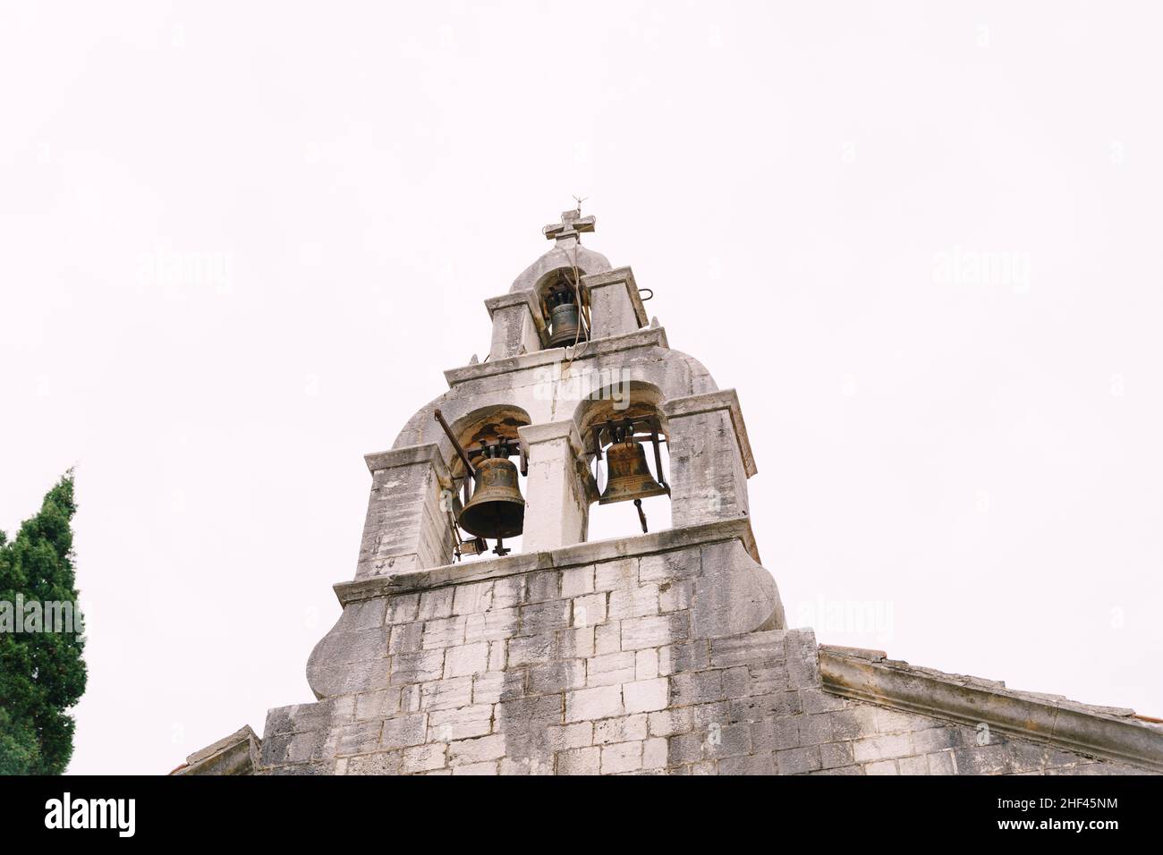 Stone bell tower with three bells against the sky Stock Photo - Alamy