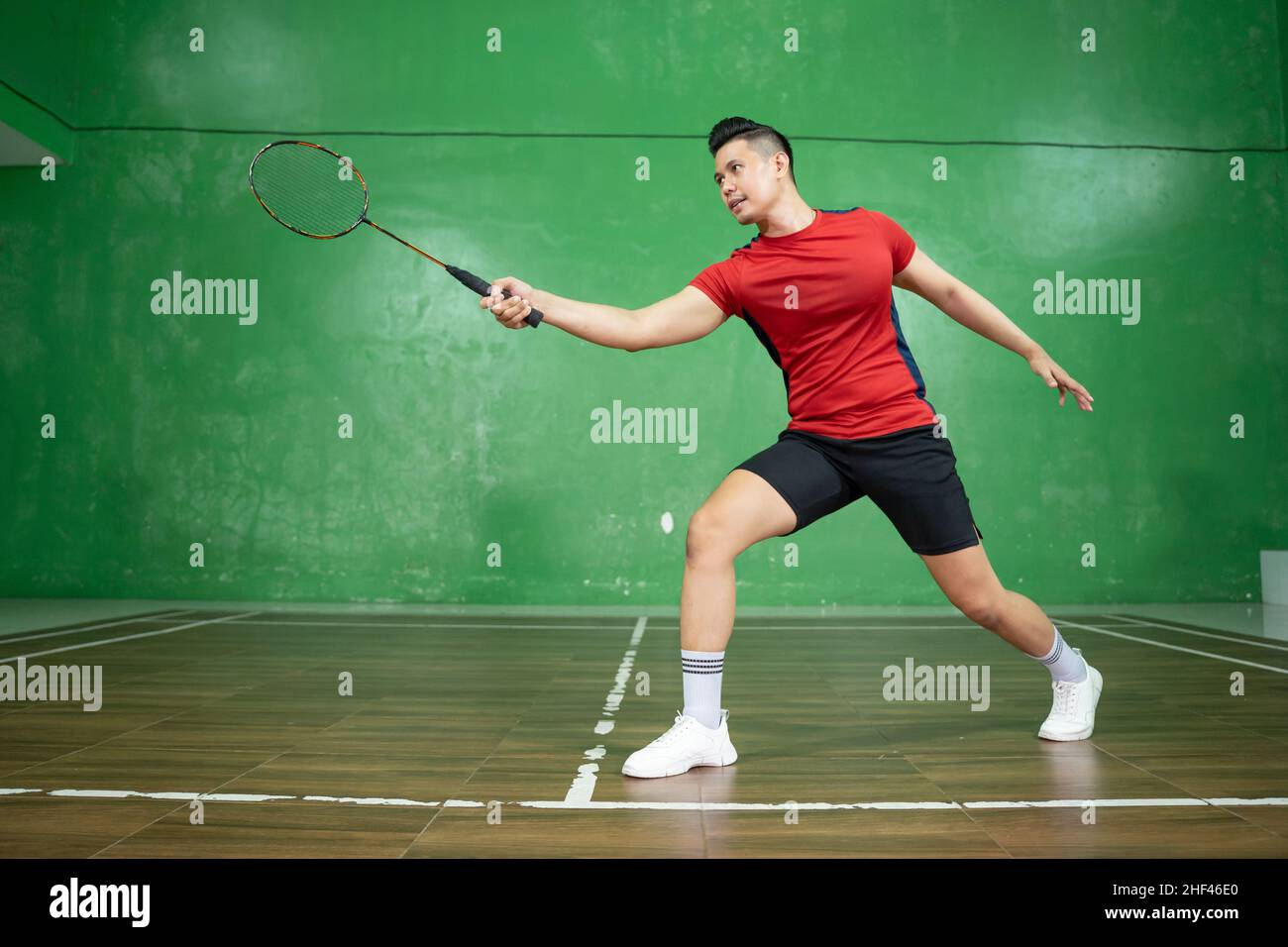 Badminton player swings the racket when stepping wide Stock Photo - Alamy