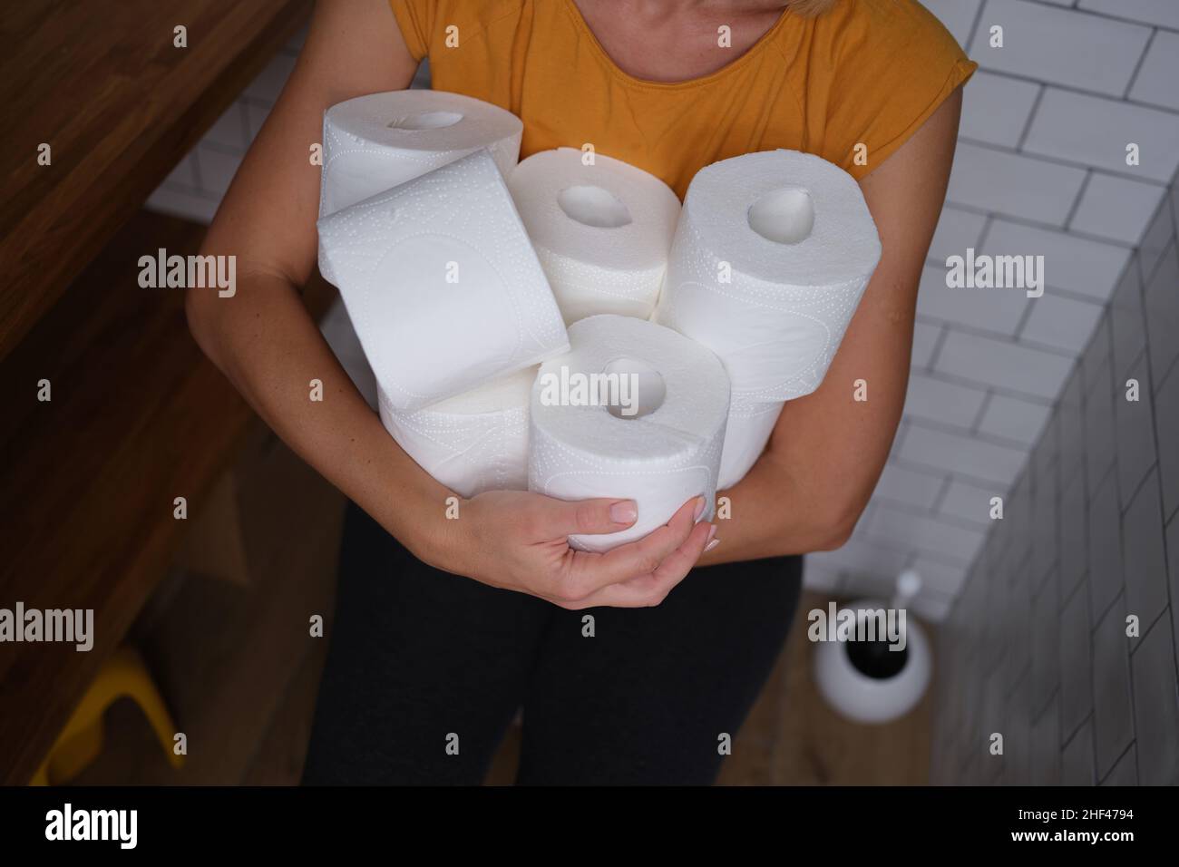 Woman in the wc holds many rolls of toilet paper Stock Photo - Alamy