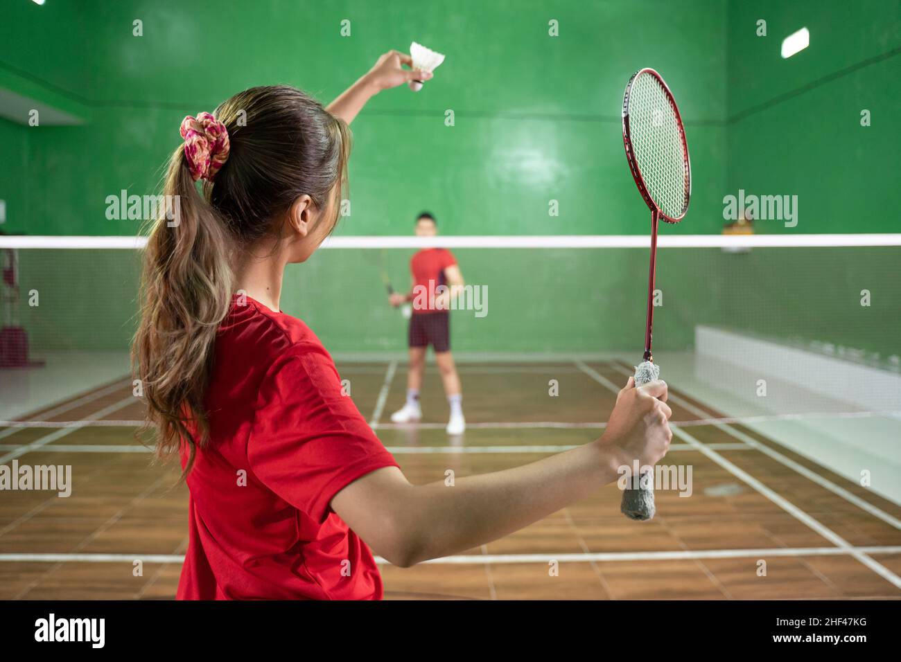 Female badminton player holding shuttlecock and racket in service ...