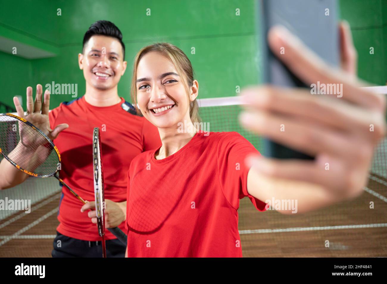 Male and female badminton players smiling while taking a selfie Stock ...