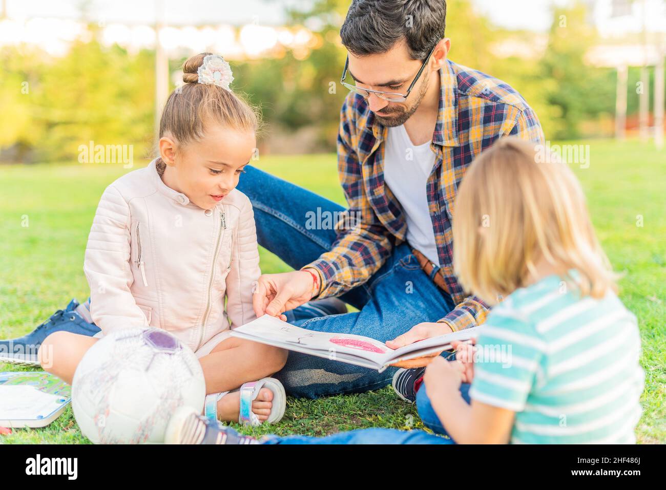 A young single father reading a book to his children Stock Photo - Alamy