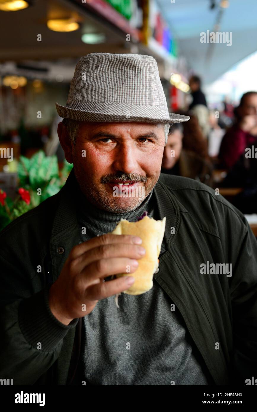 A Turkish man enjoying a fish sandwich under the Galata bridge in ...
