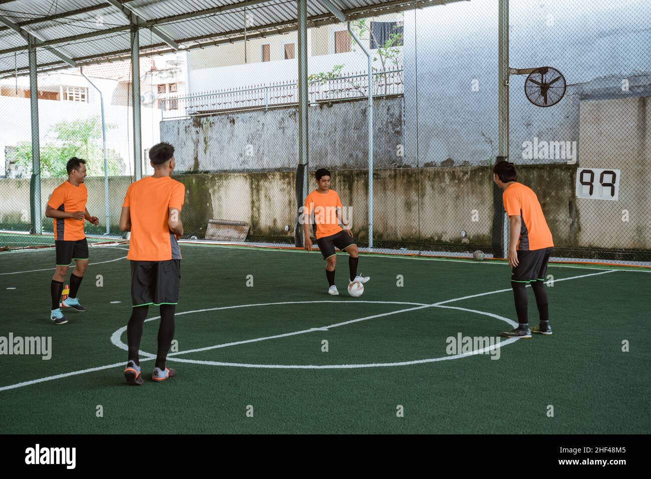 four futsal players practice passing the ball Stock Photo - Alamy