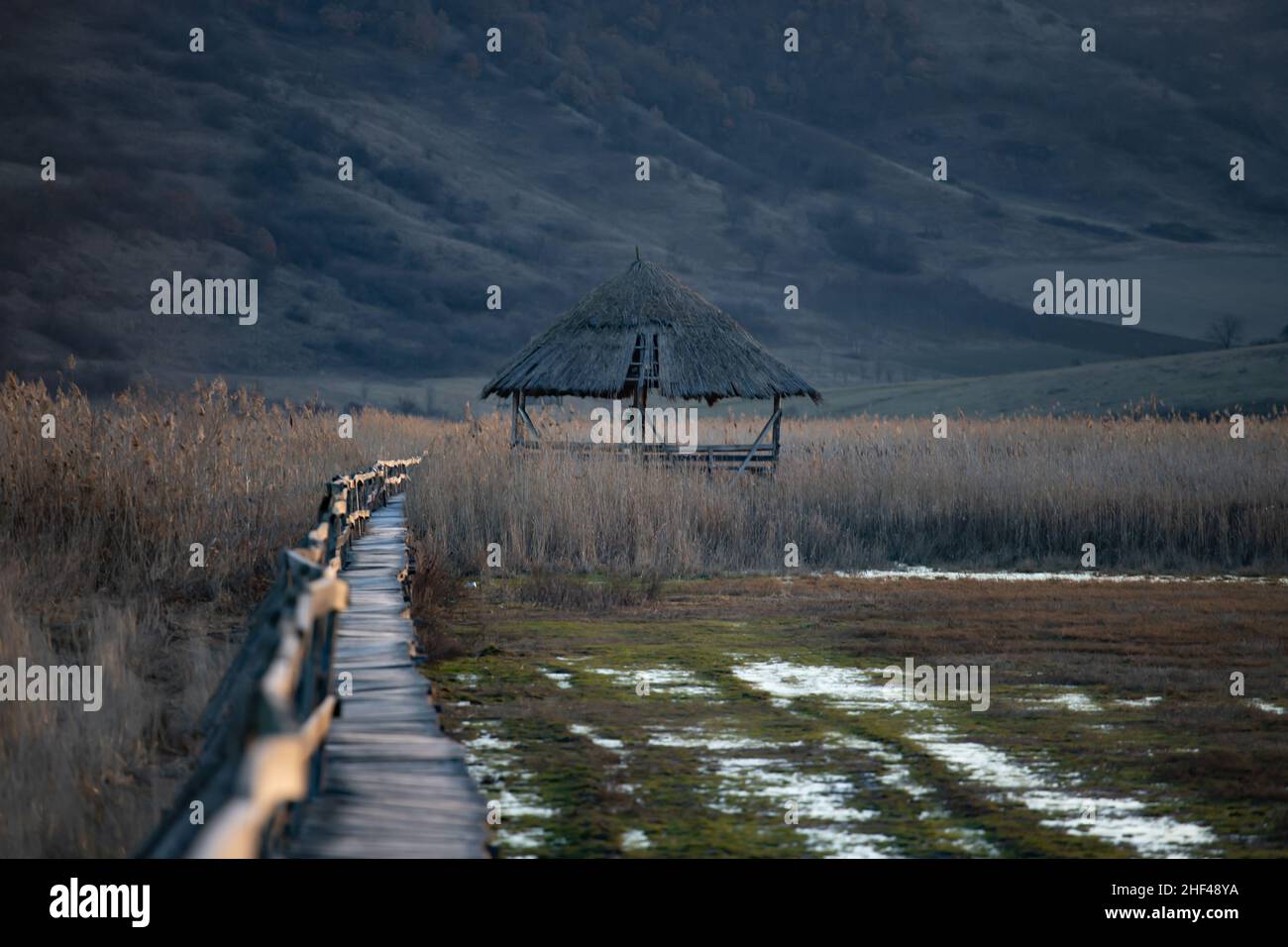Old wooden boardwalk with a railing on the side and watchtower in the ...
