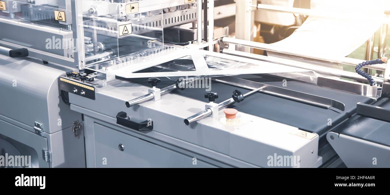 Package shrink film wraping machine in modern warehouse Stock Photo - Alamy