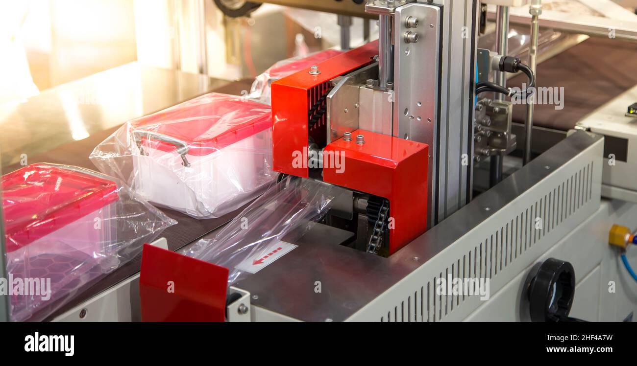 Automated food packing machine. Food container flow wrapping machine ...