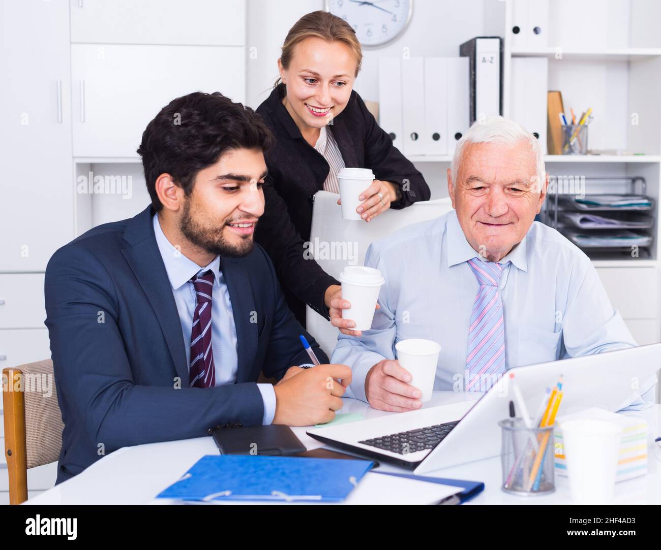 Employees are demonstrating reports on laptop to mature boss Stock ...