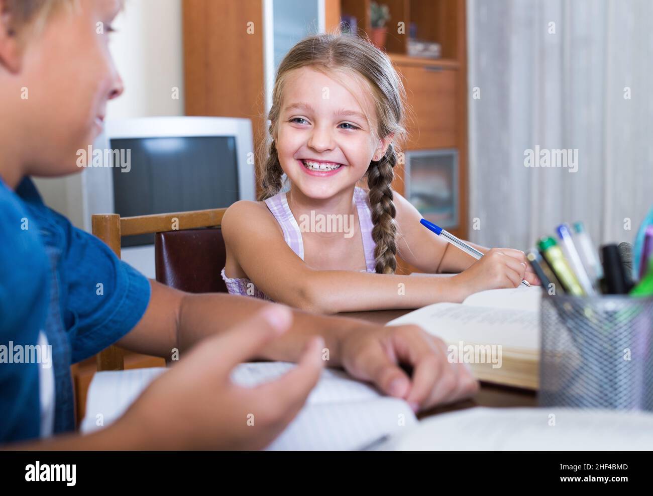 Girl doing homework with big brother Stock Photo - Alamy