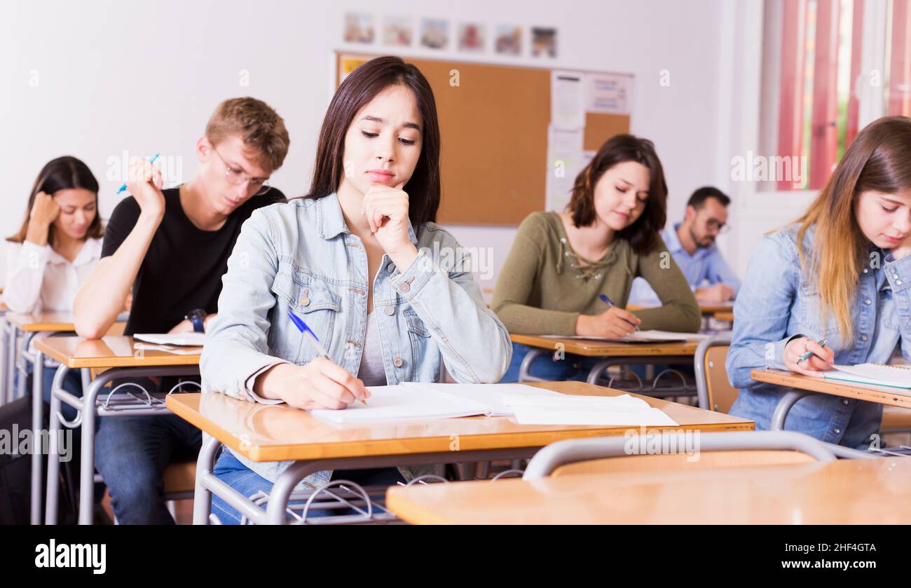 schoolgirl is sitting test and answer about task Stock Photo - Alamy