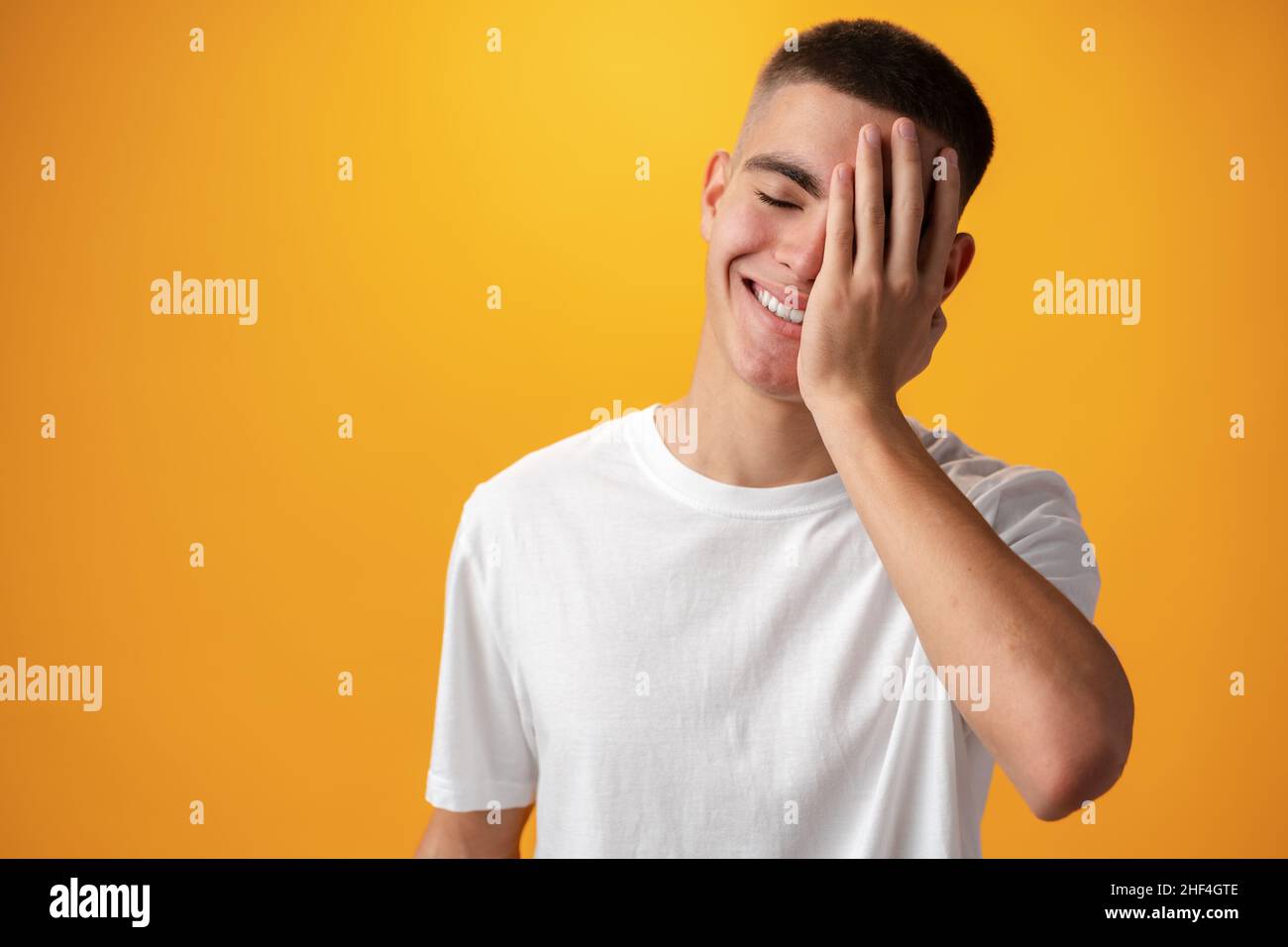 Sad teenager boy failed, touching face against yellow background Stock ...