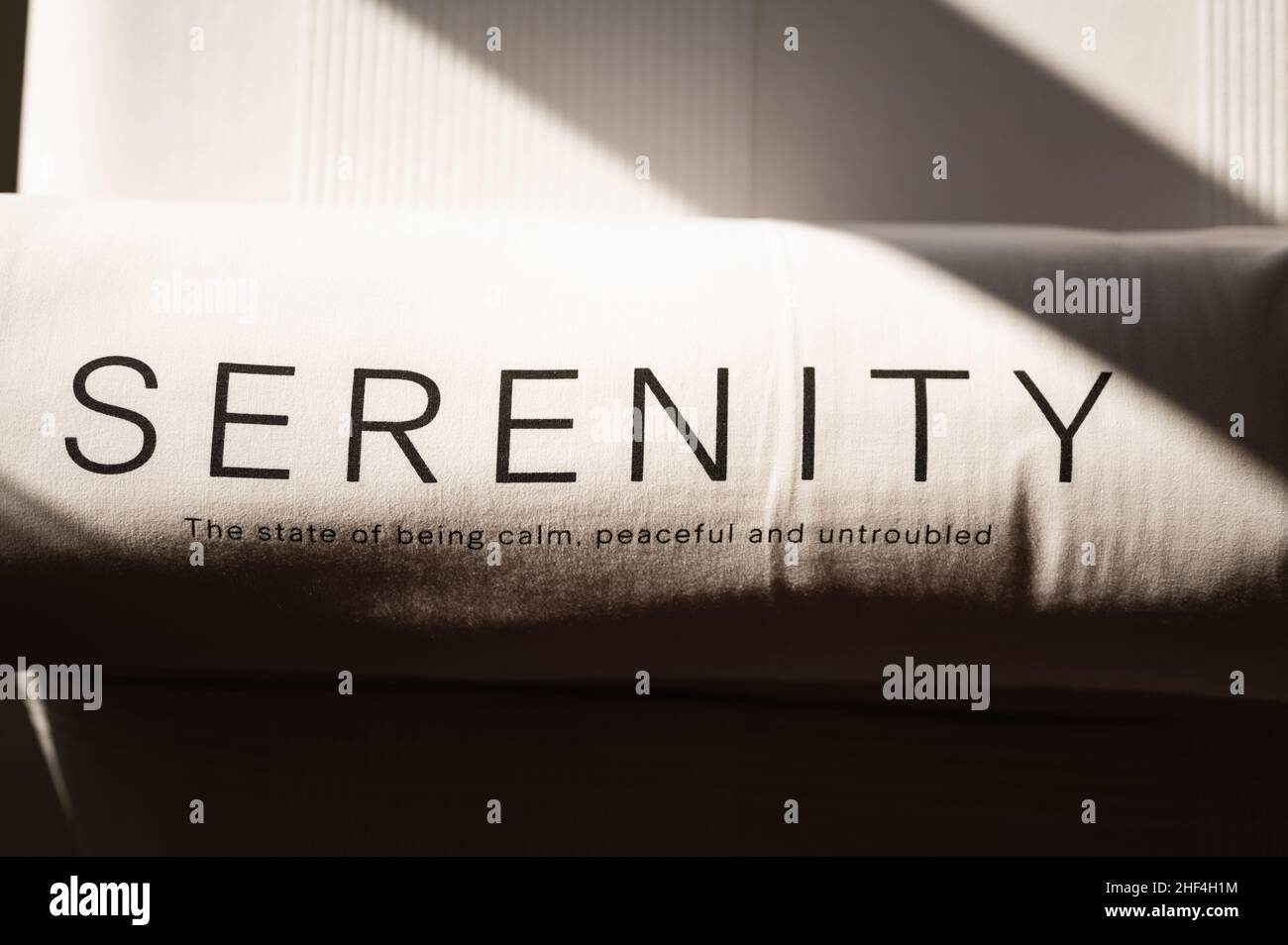 Word Serenity printed on white pillow. Concept of being calm, peaceful ...