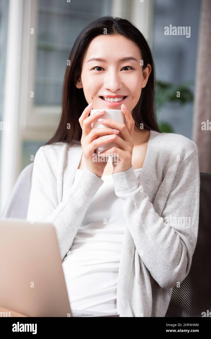 Young woman drinking coffee at home Stock Photo - Alamy