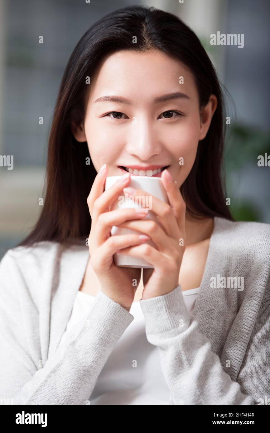 Young woman drinking coffee at home Stock Photo - Alamy