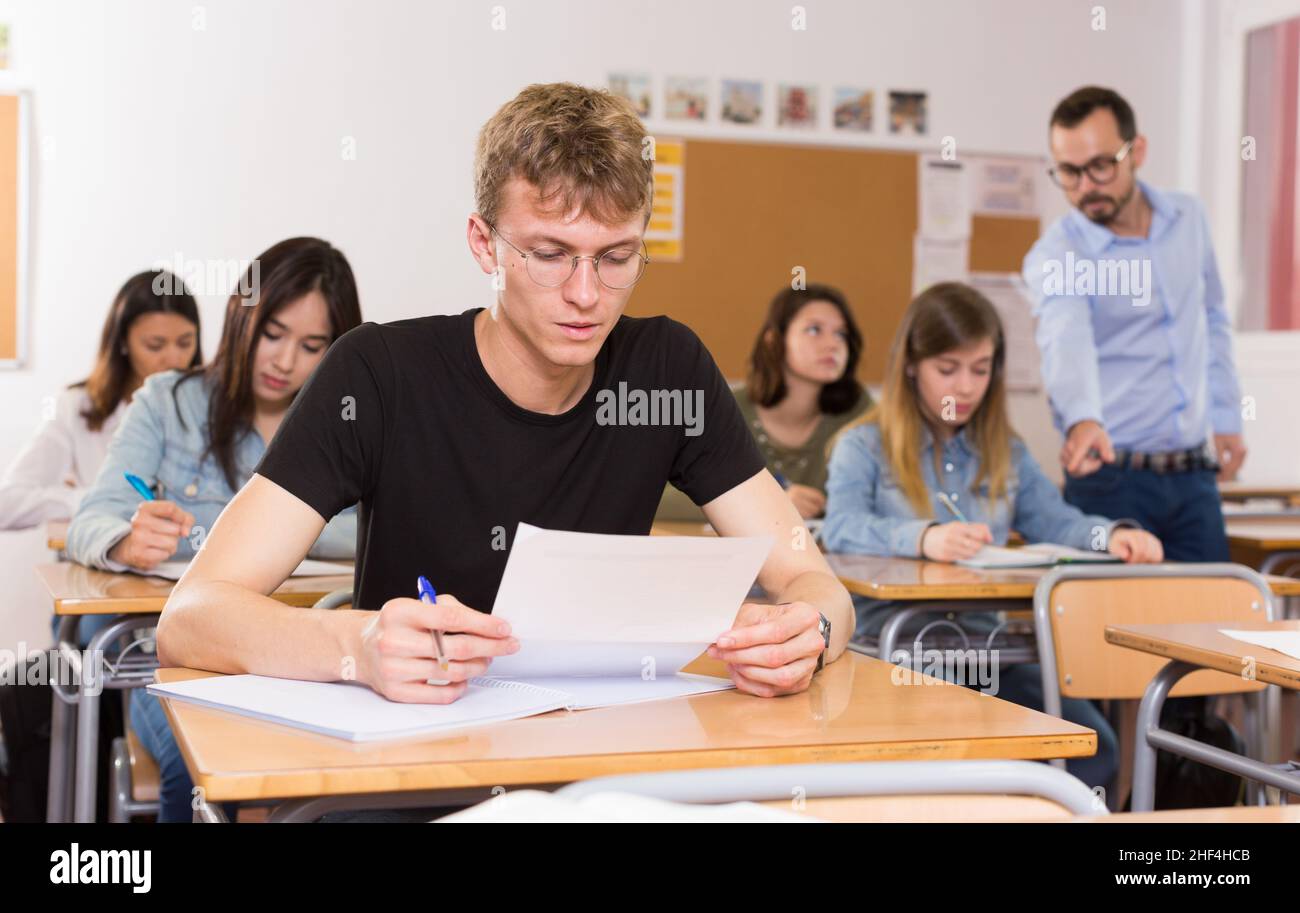 Schoolboy is learning and answering the question on paper Stock Photo ...