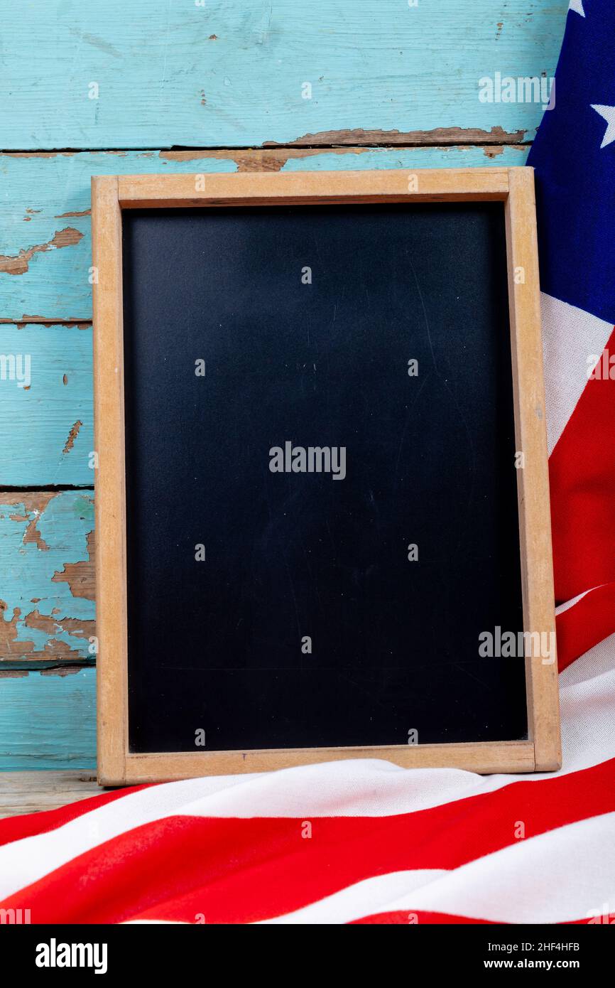 Overhead view of blank writing slate with copy space by usa flag on blue wooden table Stock ...