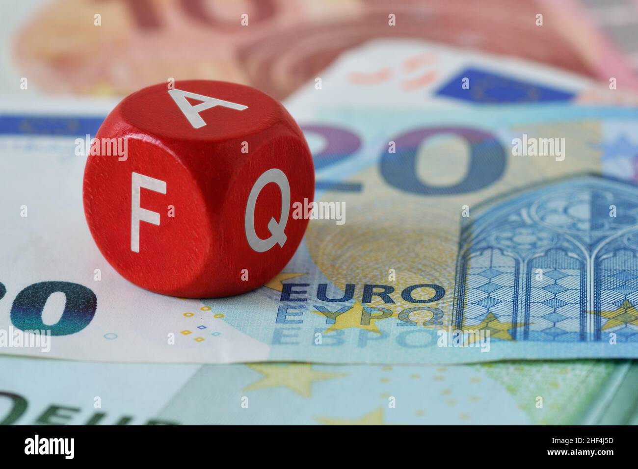 Wooden dice with the Word FAQ on euro banknotes background - Concept of ...