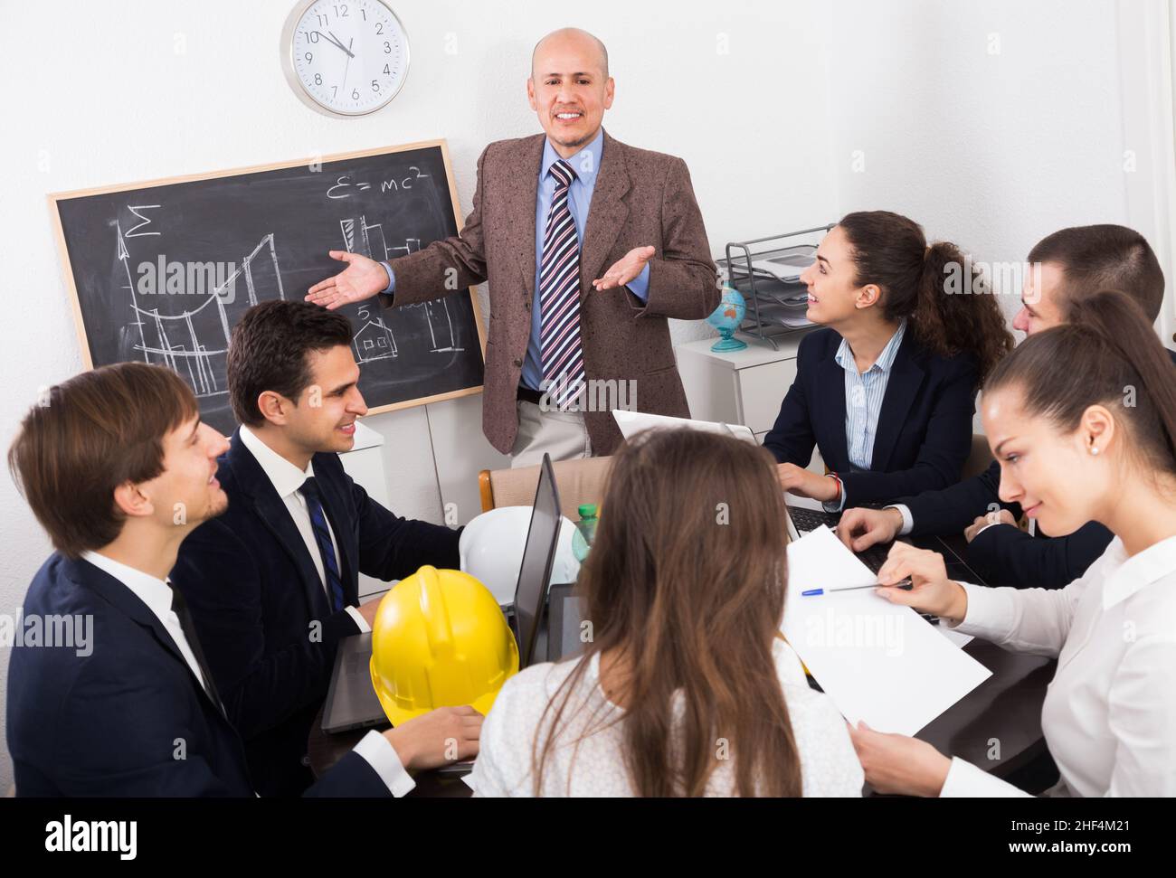 Team of adult engineers discussing new project Stock Photo - Alamy