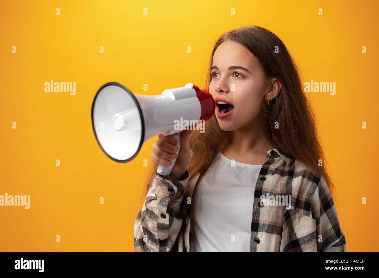 Child girl using megaphone against yellow background Stock Photo - Alamy
