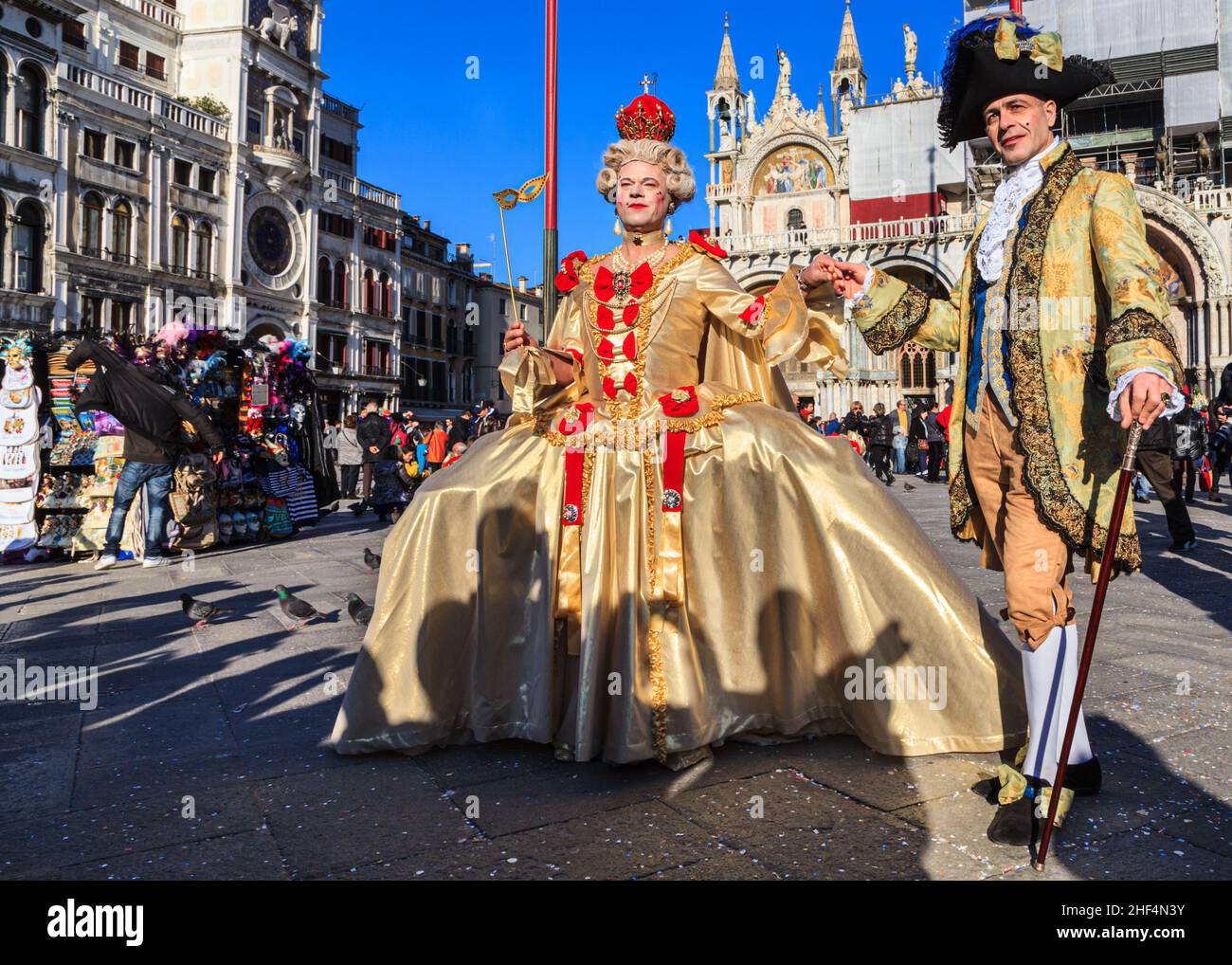 Photographers cast shadows on a participant posing as a flamboyant ...