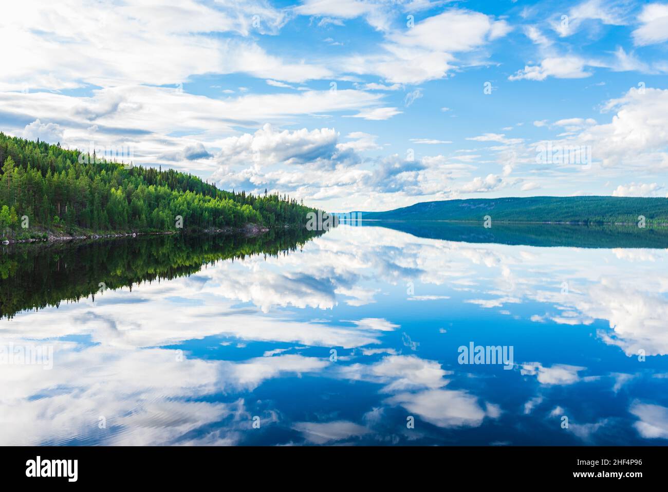 Clouds reflecting in a mirror lake Stock Photo - Alamy