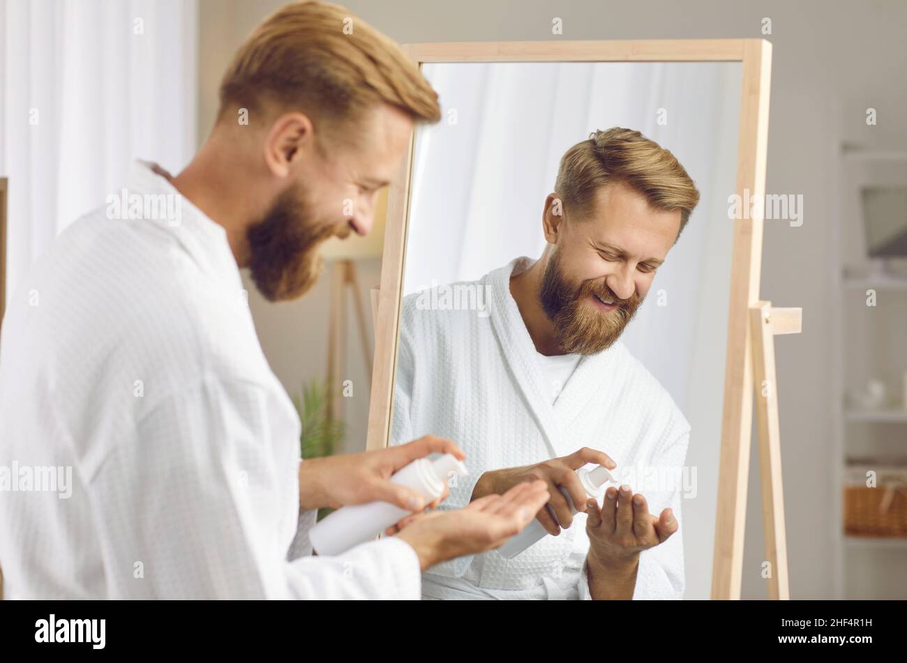 Smiling man apply face cream for healthy glowing skin Stock Photo - Alamy