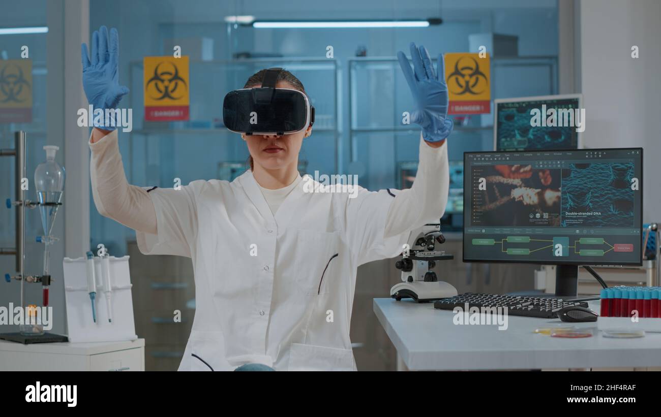 Woman biologist using vr glasses in science laboratory to work on ...