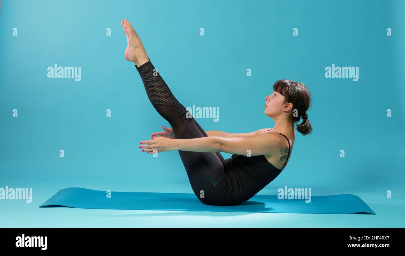 Fit athlete finding balance with stretching exercise on yoga mat after ...