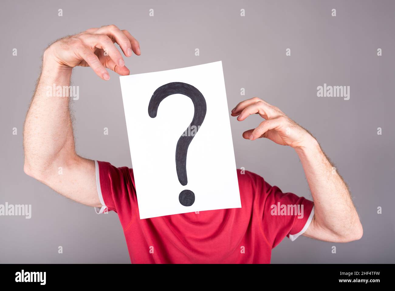 Man behind a paper with a question mark Stock Photo - Alamy
