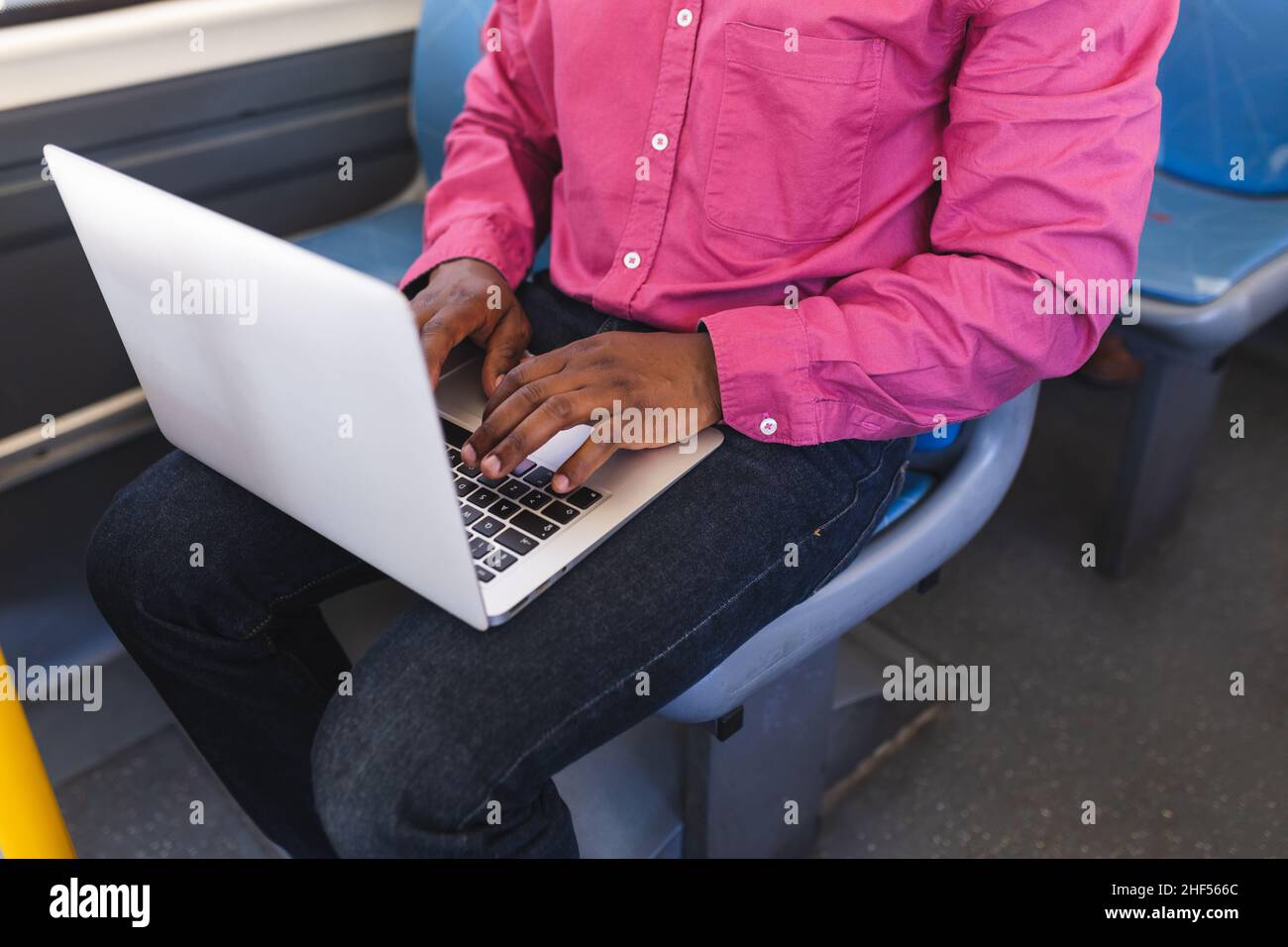 Mid section of a businessman using laptop on the bus on the go to ...