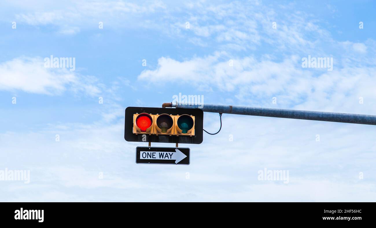 red traffic light with one way sign under blue sky Stock Photo - Alamy