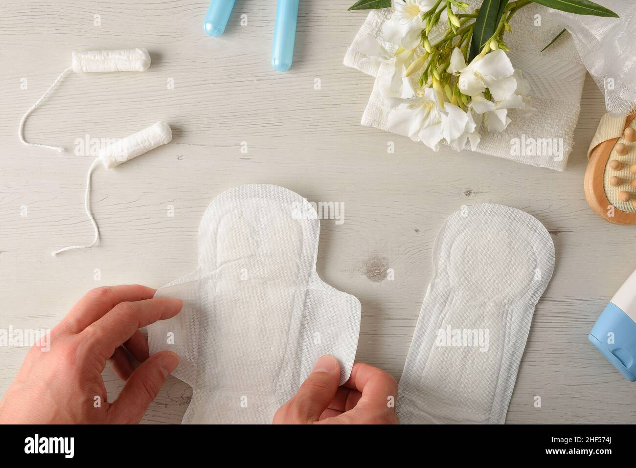 Hands preparing various menstrual hygiene products, and intimate ...