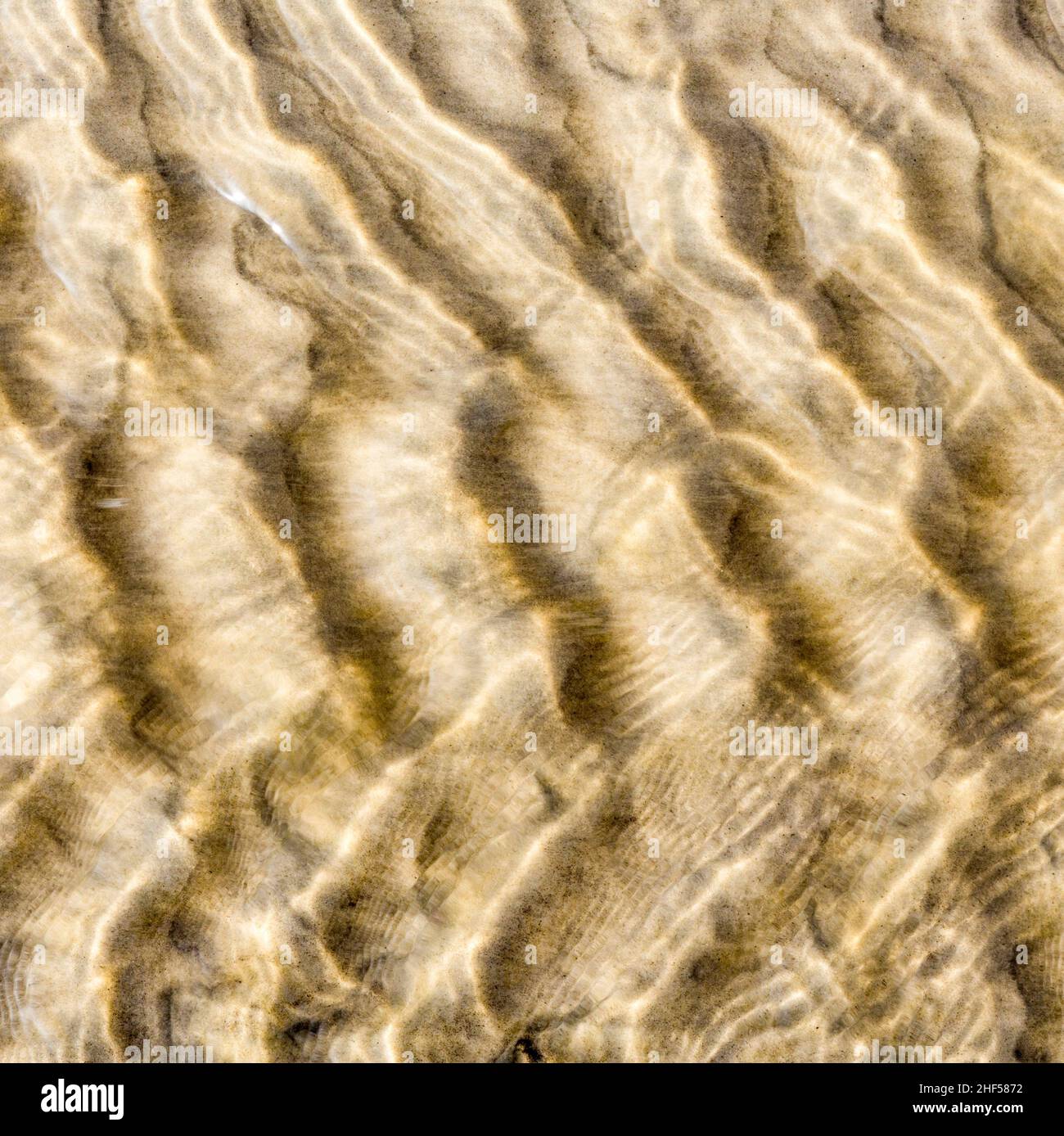 Sand see through water background Stock Photo - Alamy