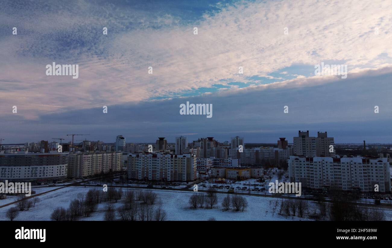 Flying over a snowy park. The city is visible on the horizon. Aerial ...